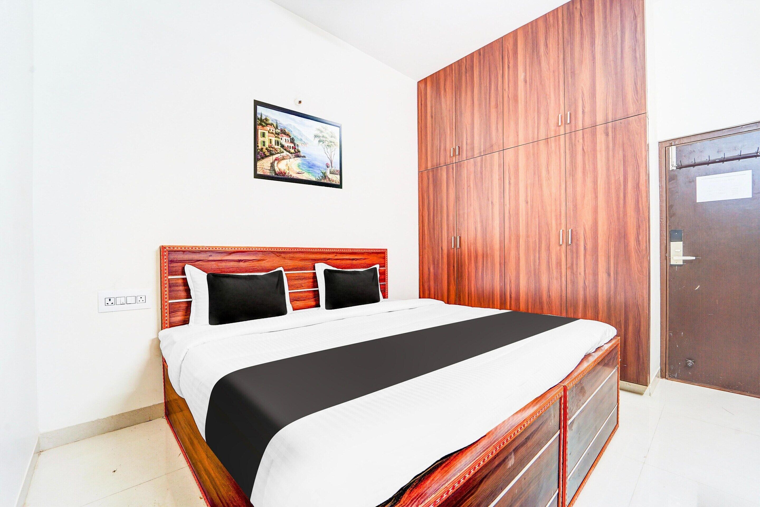 Quarto com cama, guarda-roupa de madeira e um quadro na parede.