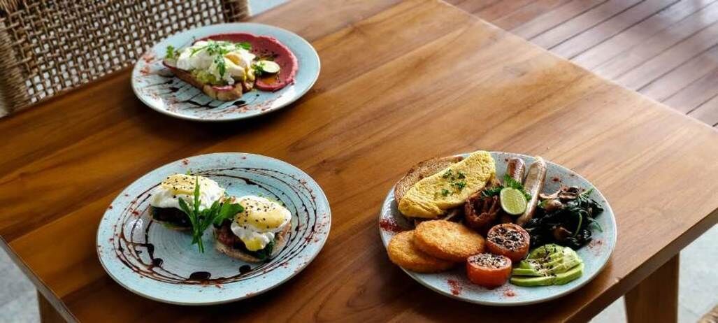 Uma mesa de madeira com três pratos de comida.