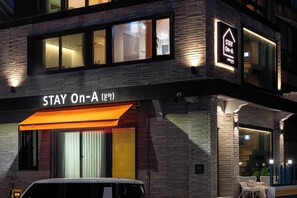 Um hotel com uma placa 'STAY On-A', fachada de tijolos e um carro estacionado na frente.