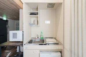 Uma cozinha compacta equipada com micro-ondas, pia e armários.
