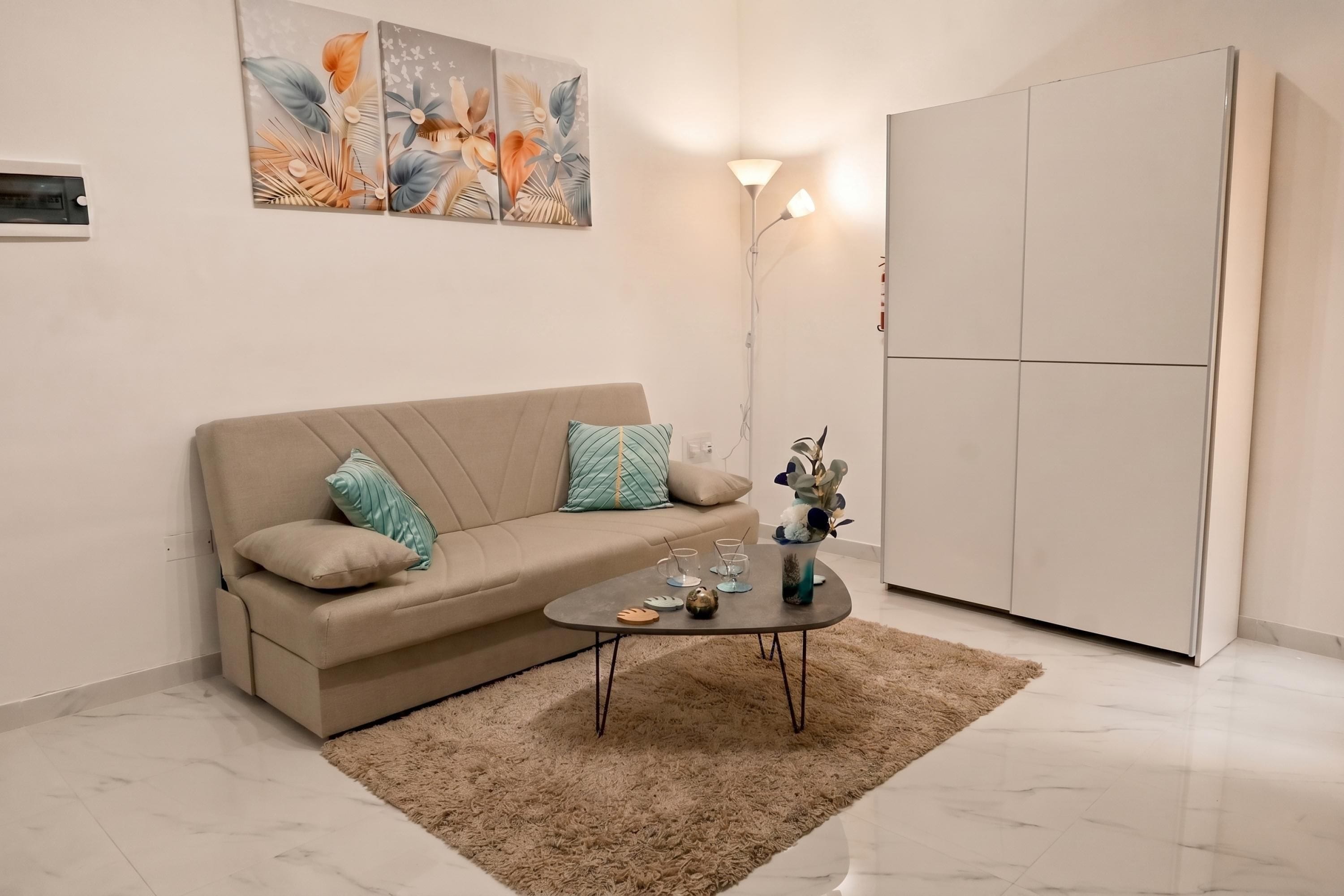 Uma sala de estar moderna com sofá, mesa de centro e objetos decorativos.