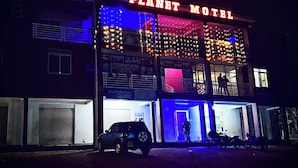 Um edifício com uma placa indicando 'PLANET MOTEL' e uma clínica visível.
