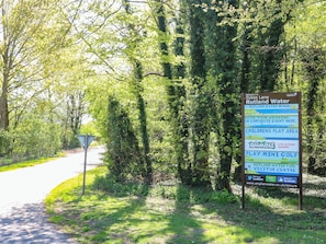 Painel informativo sobre Rutland Water, com comodidades como área de recreação infantil, campo de mini golfe e centro de visitantes.