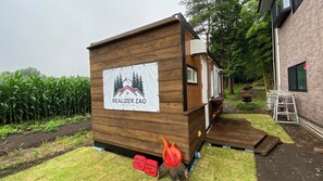 Uma cabana de madeira com uma placa indicando 'REALIZER ZAO' e um braseiro em formato de urso.