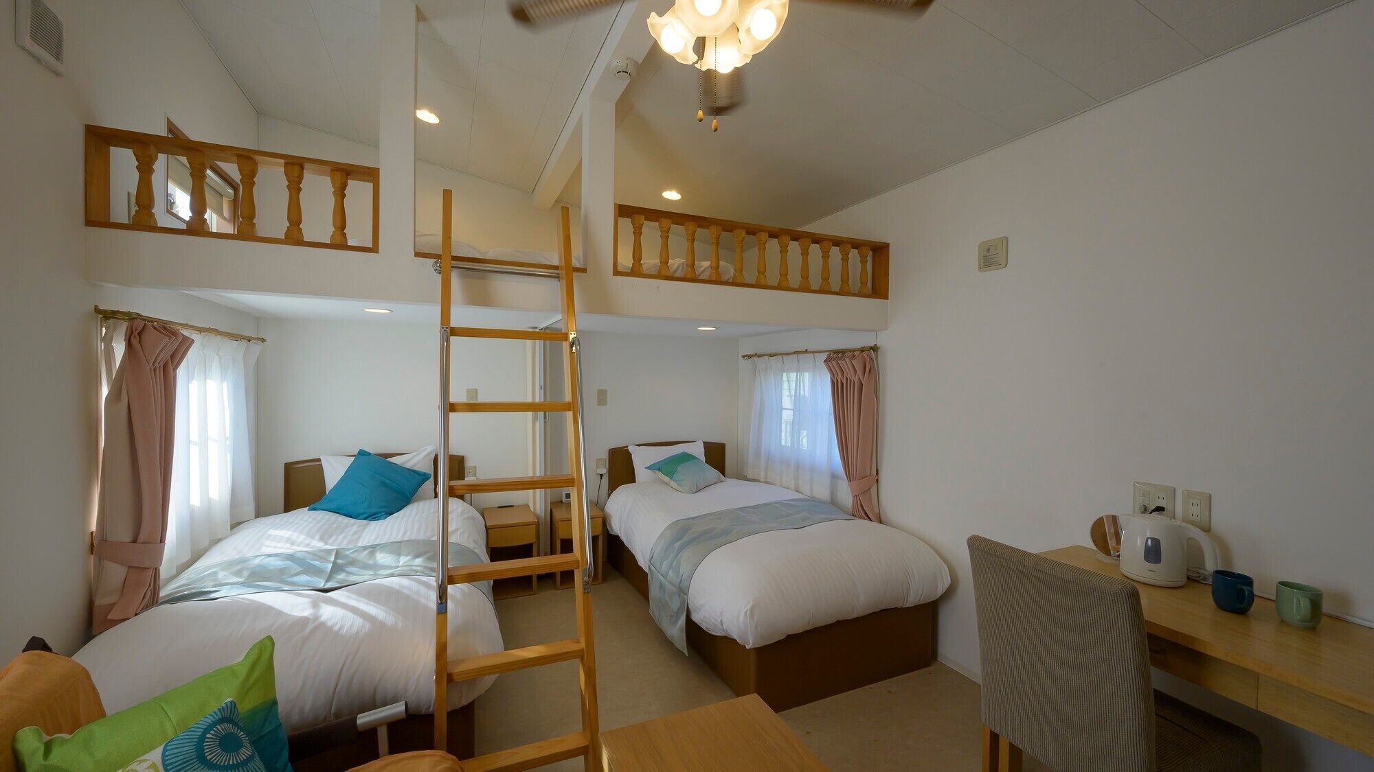 Quarto com duas camas, uma escrivaninha, uma cadeira, uma escada e um lustre.