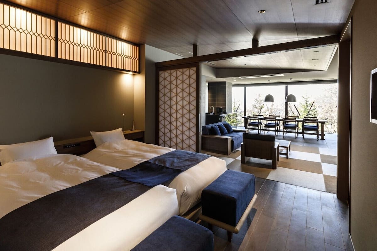 Quarto de hotel com uma cama grande, uma escrivaninha e vista para o exterior.