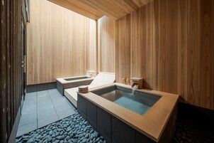 Um spa moderno com paredes de madeira e uma grande banheira de hidromassagem central.
