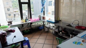 Cozinha com janela, pia e diversos utensílios.