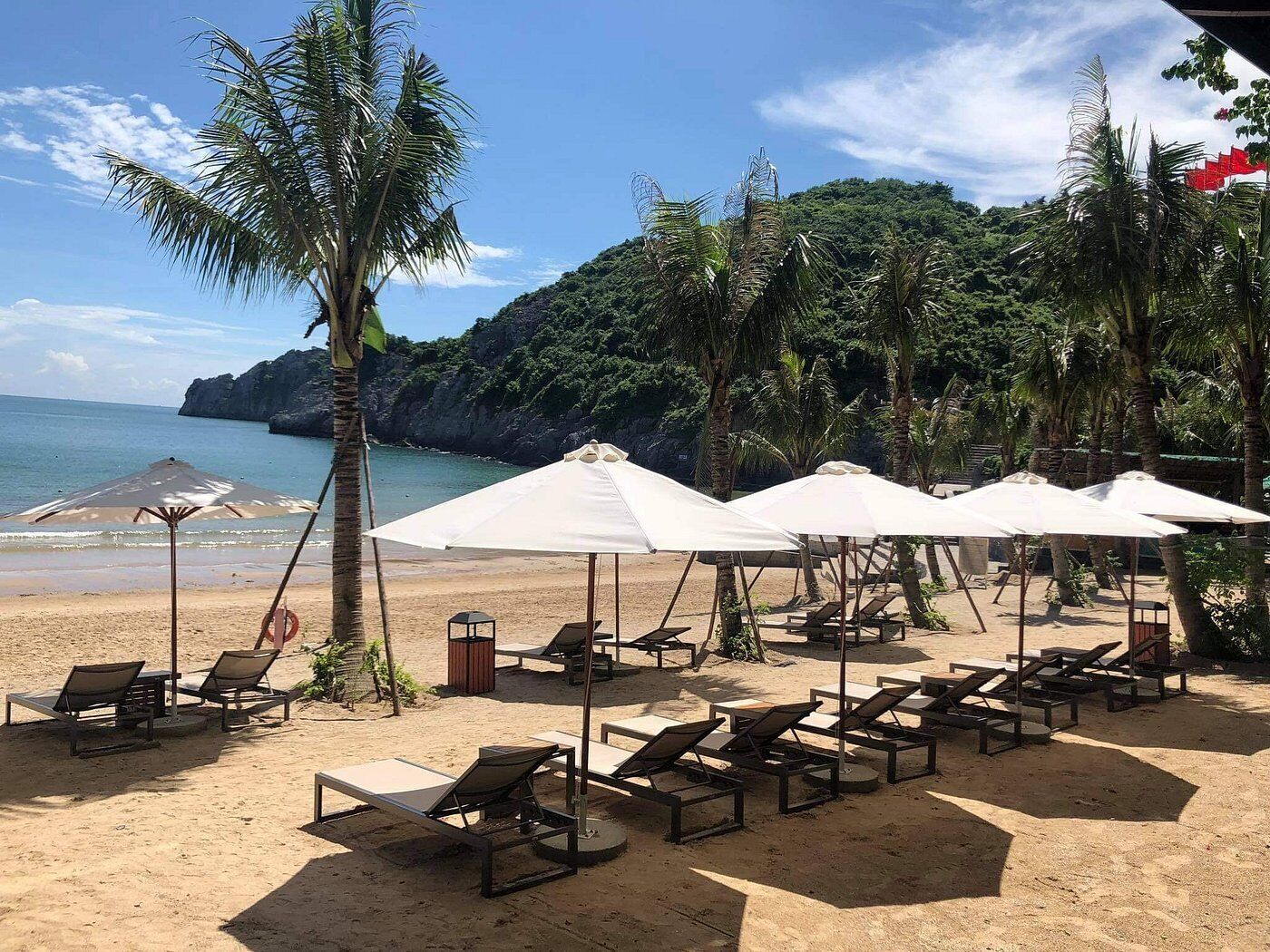 Na praia, areia branca, barracas de praia de cortesia, espreguiçadeiras 