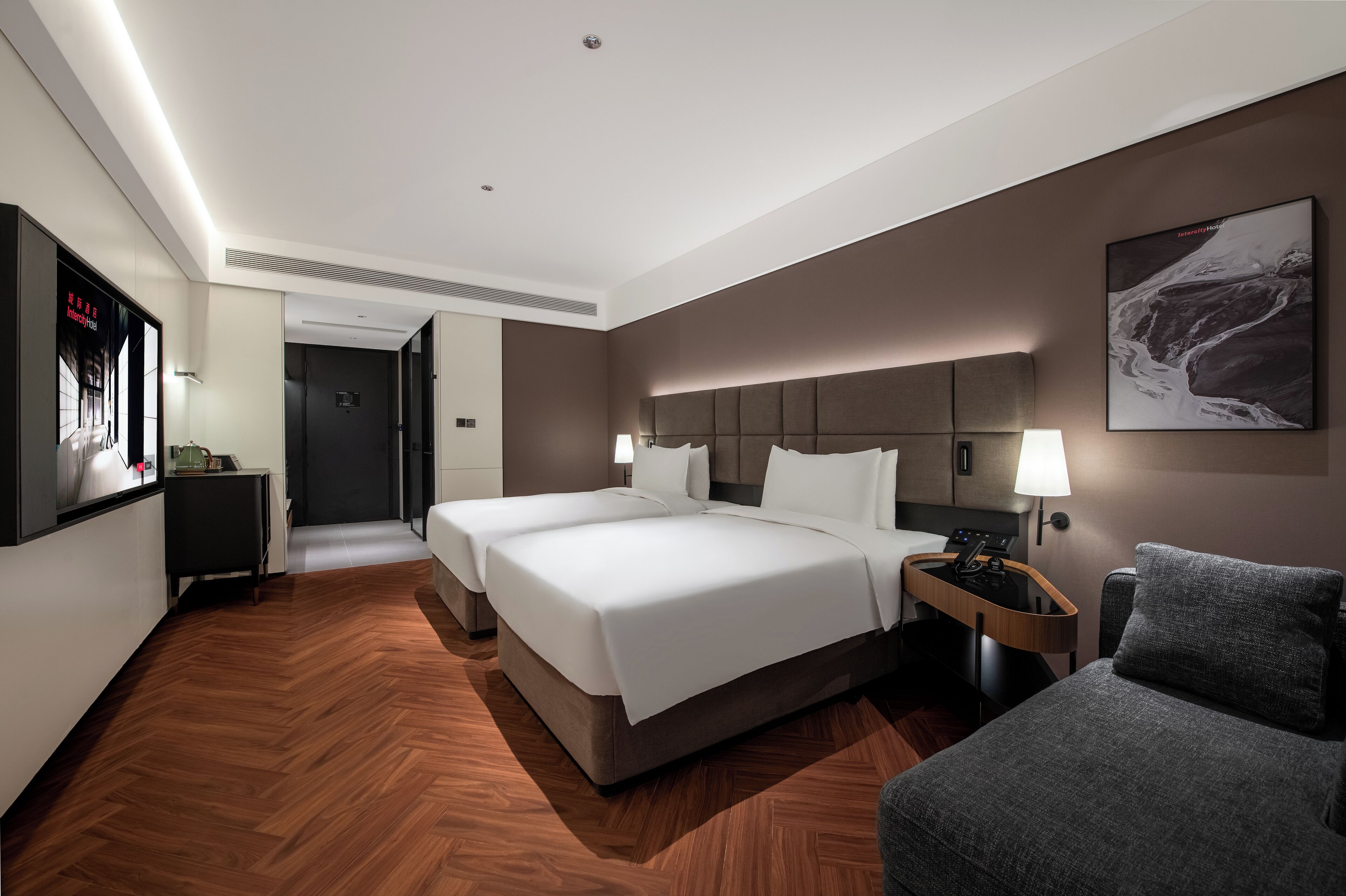 Quarto de hotel com uma cama grande, mesas de cabeceira, uma escrivaninha e uma cadeira.