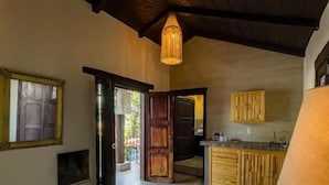 Um quarto amplo com piso de madeira, um armário grande de madeira e um lustre.