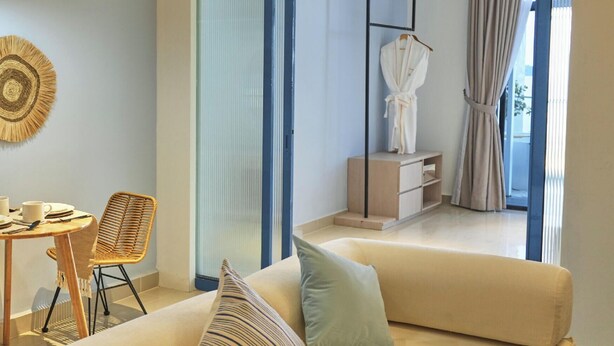 Quarto de hotel moderno com sofá, mesa de jantar e guarda-roupa.