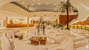 Um hall amplo com balcão de recepção, área de estar e escada.