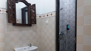 Casa de banho com lavatório, espelho e zona de duche.