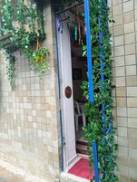 Uma entrada com um tapete vermelho, uma porta branca e um marco azul.