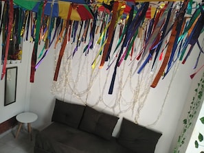 Quarto com sofá, mesinha e espelho.