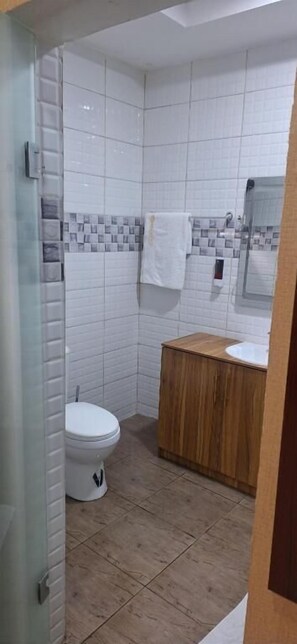 Chuveiro, toalhas de banho, sabonete, papel higiênico
