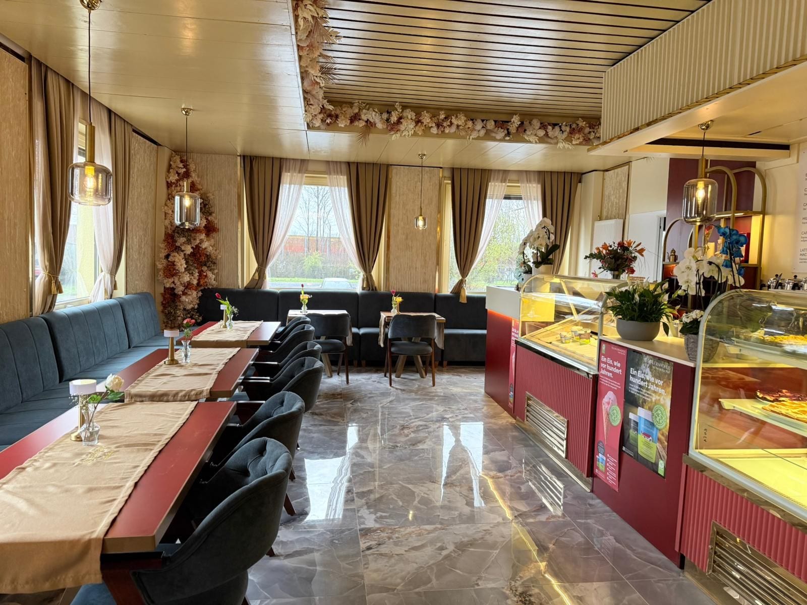Restaurante com balcão extenso, assentos acolchoados e vitrine de sobremesas.