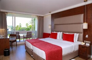 Quarto de hotel com uma cama grande, uma escrivaninha e uma cadeira.