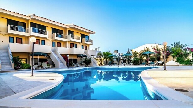 Área de piscina com um edifício ao fundo.