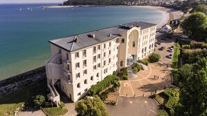 Hotel de vários andares com um pátio central, rodeado por uma praia e vista para o oceano.