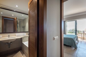 Casa de banho moderna com lavatório, espelho e chuveiro.
