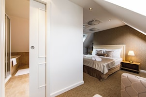 Quarto com cama, mesa de cabeceira e janela.