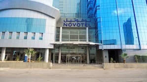 Um hotel moderno com fachada de vidro imponente e entrada curva.