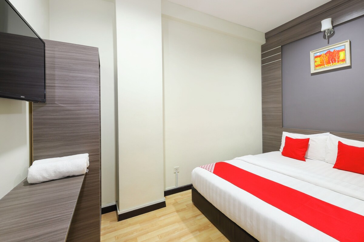 Quarto de hotel moderno com uma cama, uma televisão de tela plana e um quadro na parede.