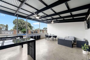 Amplo espaço interno com teto alto, janelas grandes e disposição de assentos.