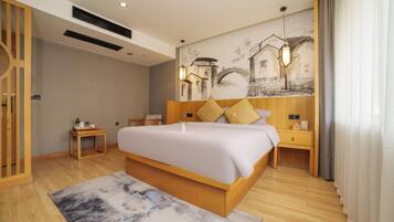 Quarto de hotel moderno com uma cama grande, cabeceira de madeira, mesa de cabeceira e um mural na parede.