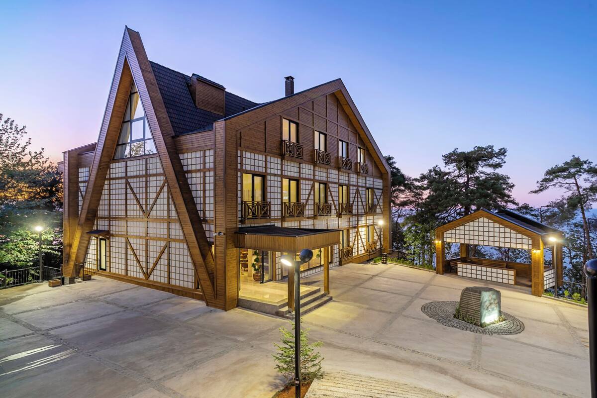 Uma casa moderna com uma varanda grande, um alpendre coberto e um caminho de pedra.