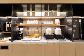 Uma cozinha moderna com eletrodomésticos de aço inoxidável, cafeteira e geladeira.