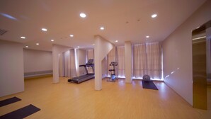 Quarto amplo com esteira ergométrica, elíptico e tapete de yoga.