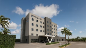 Um edifício de hotel moderno com fachada plana, várias janelas e uma placa com a inscrição 'SAN GERMAN Hotel'.
