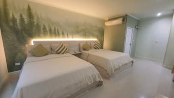 Quarto com duas camas, um mural na parede e aparelho de ar condicionado.