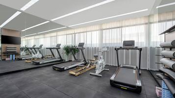 Uma academia moderna com esteiras, bicicletas ergométricas e máquinas de remo.