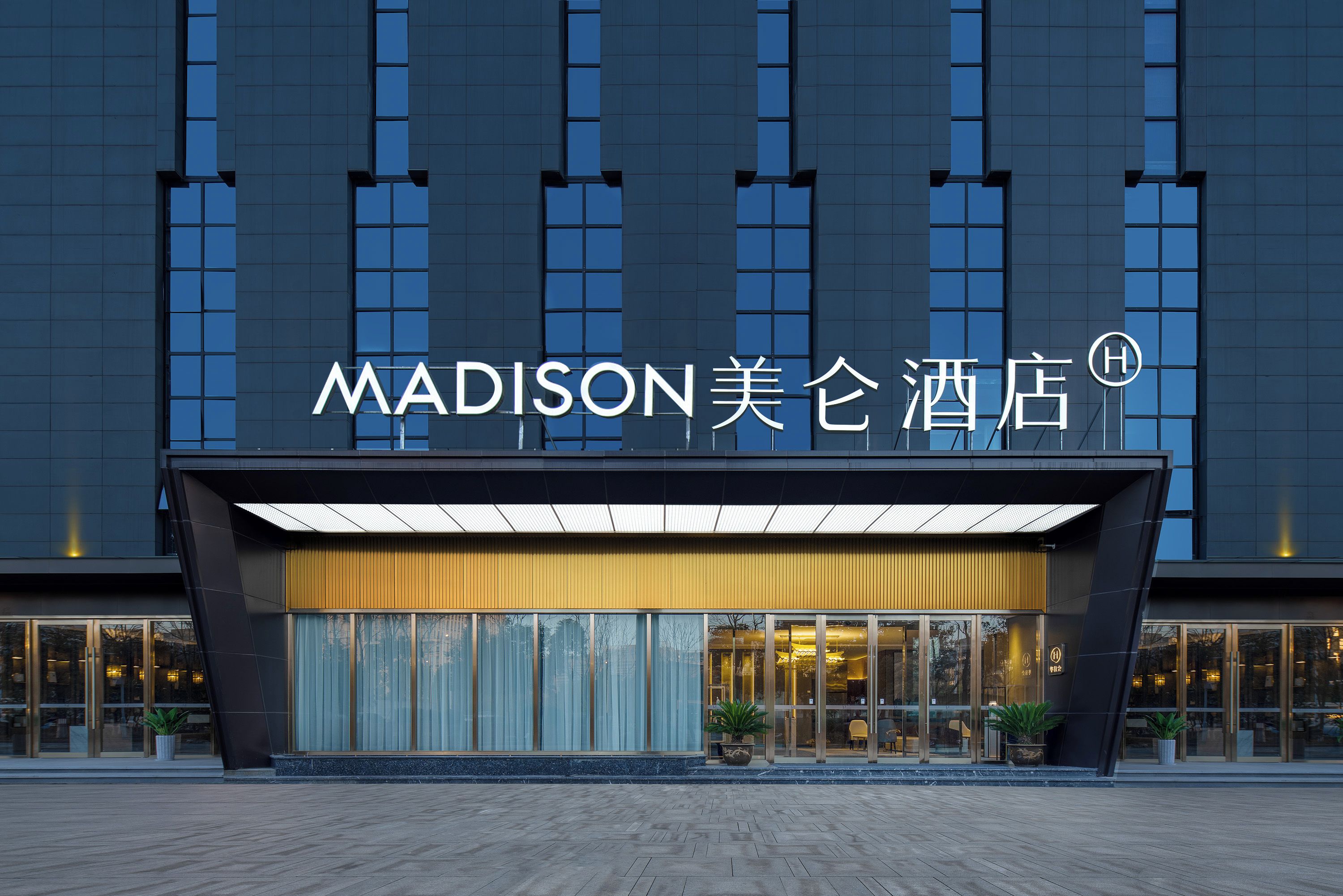 Fachada moderna de hotel com uma grande placa com a inscriç ão 'MADISON'.