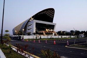 Um edifício moderno com um telhado curvo distinto e uma placa com a inscrição 'Chateau Grand'.