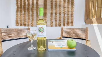 Uma mesa com uma garrafa de vinho, um copo e uma maçã em um folheto.