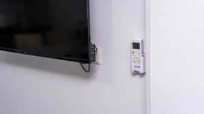 Televisão fixada na parede e um painel de controle, provavelmente para um sistema de segurança.