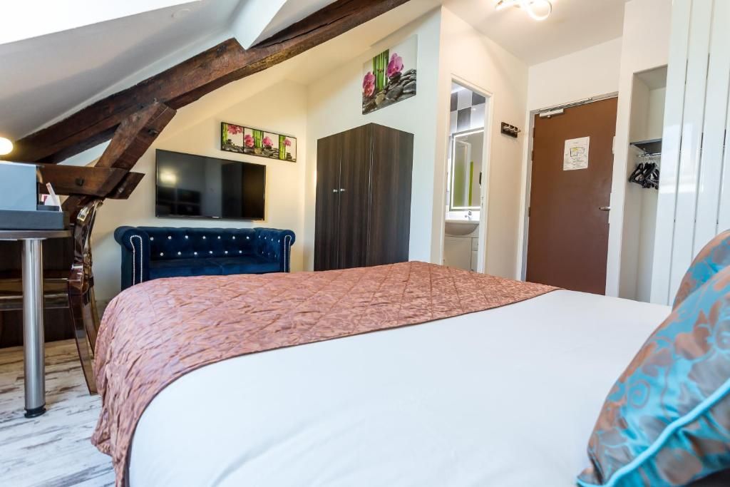 Quarto com cama, guarda-roupa, escrivaninha e televisão.