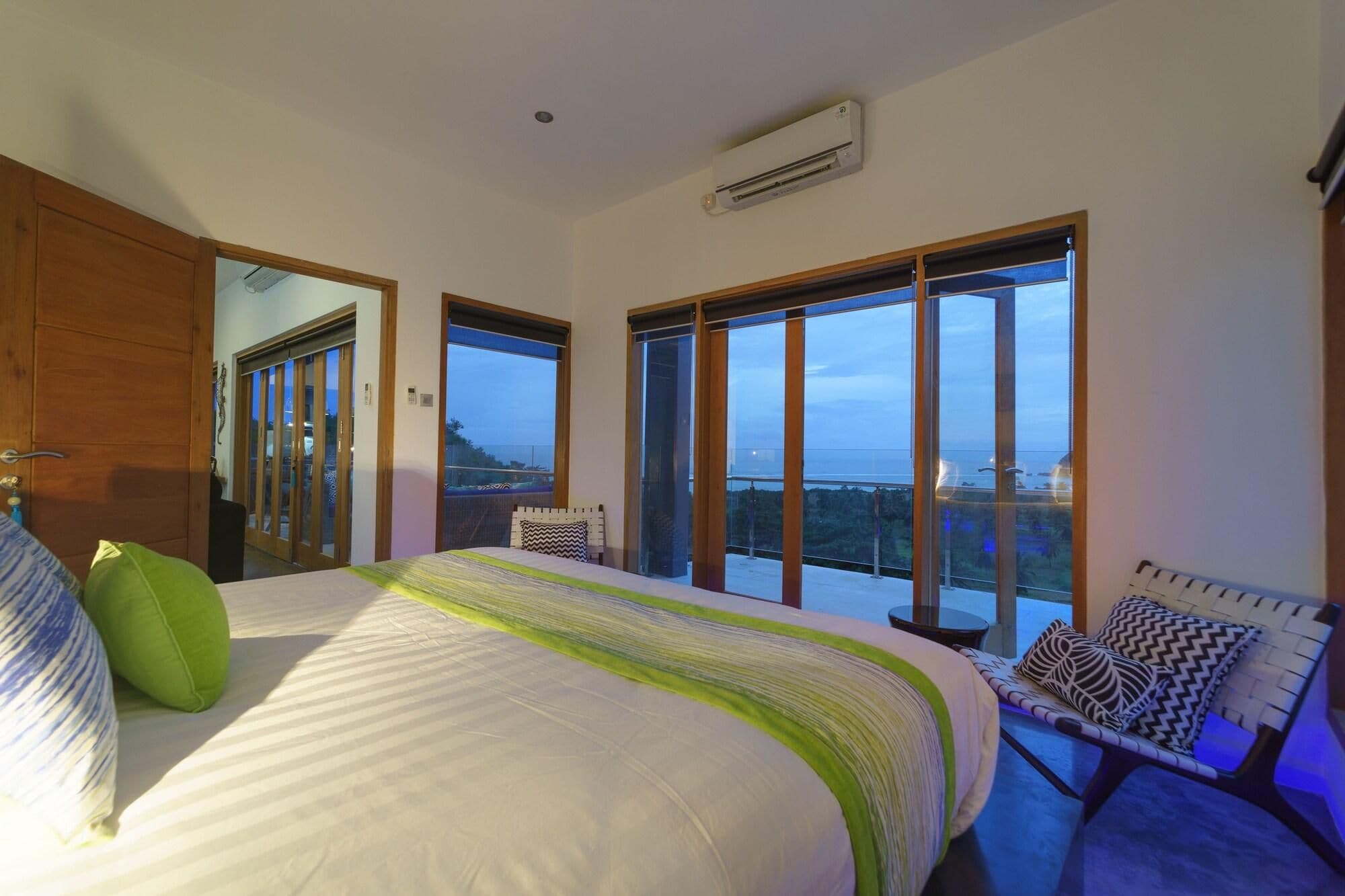 Quarto com uma cama grande, varanda com vista e ar condicionado.