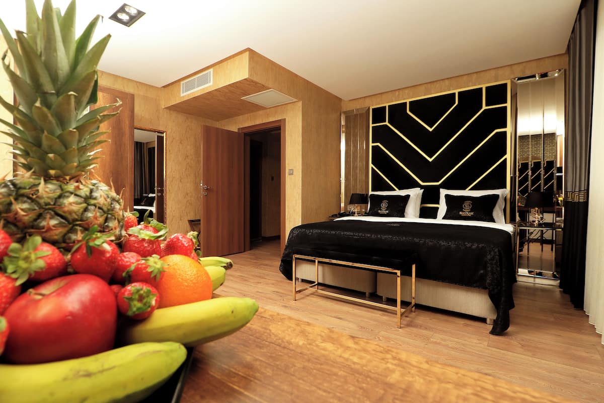 Quarto de hotel com uma cama, uma fruteira e um espelho.