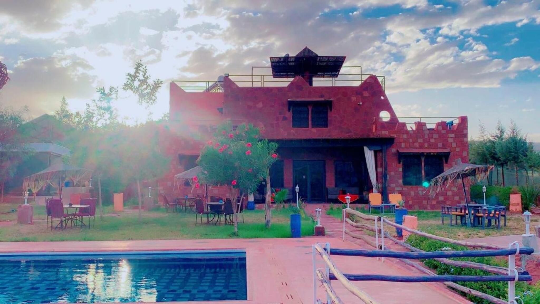 Um edifício moderno com piscina, área de estar ao ar livre e céu claro.