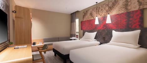 Quarto de hotel com duas camas, uma escrivaninha, uma cadeira, uma televisão e um quadro abstrato grande na parede.