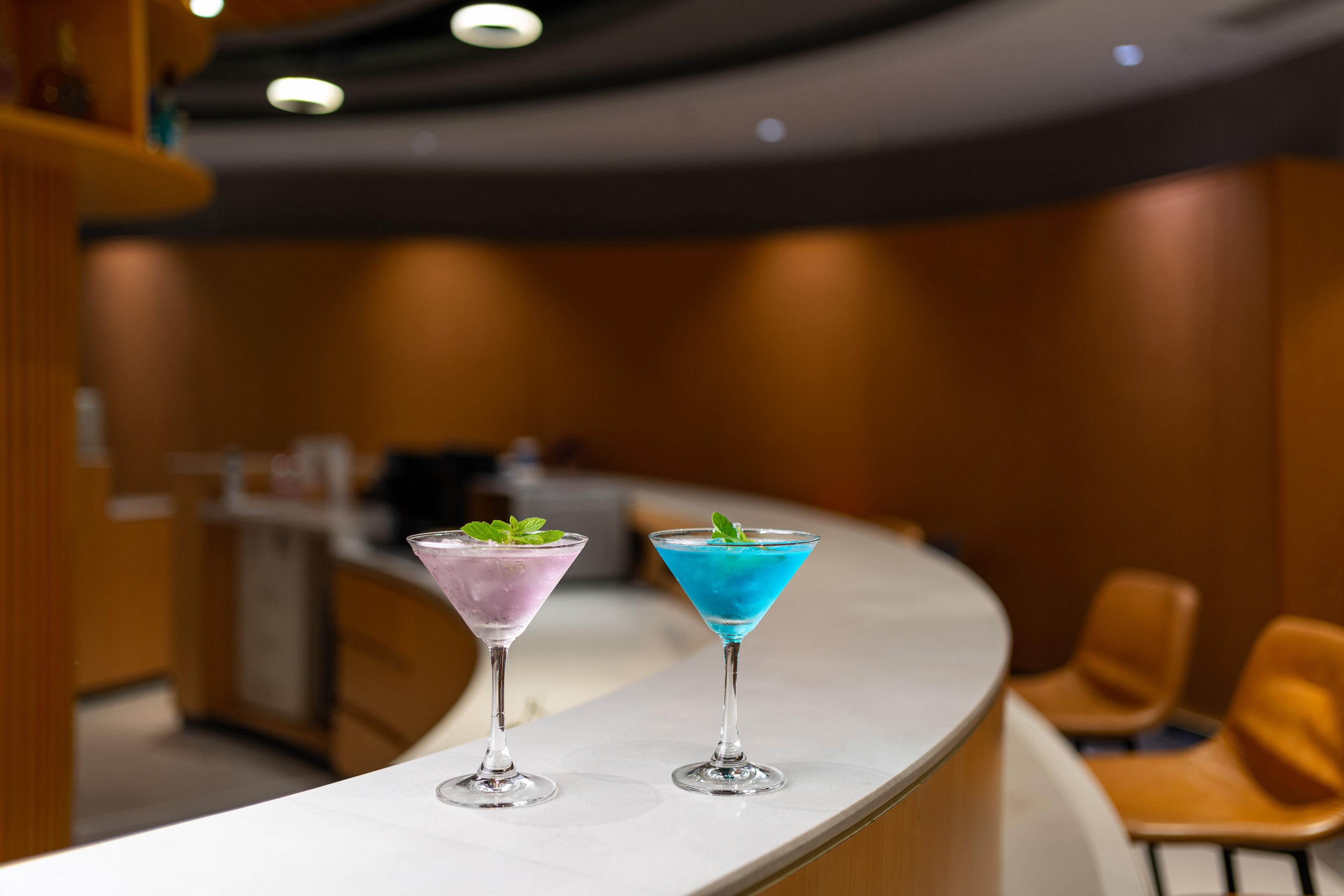 Uma área de bar com dois coquetéis e um balcão.