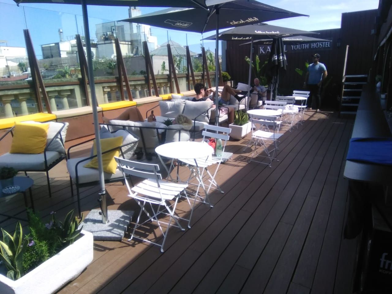 Bar no terraço com área externa, incluindo cadeiras e mesas sob guarda-sóis.