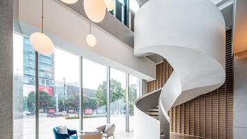 Um interior moderno com uma escada em espiral, janelas amplas e móveis contemporâneos.