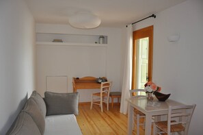 Um quarto com uma cama, uma escrivaninha e uma mesa com cadeiras.